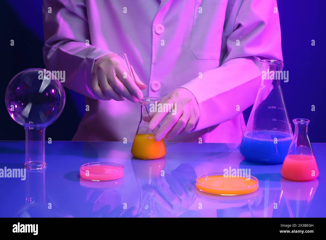 Male or female scientist is stirring the chemical liquid inside the ...