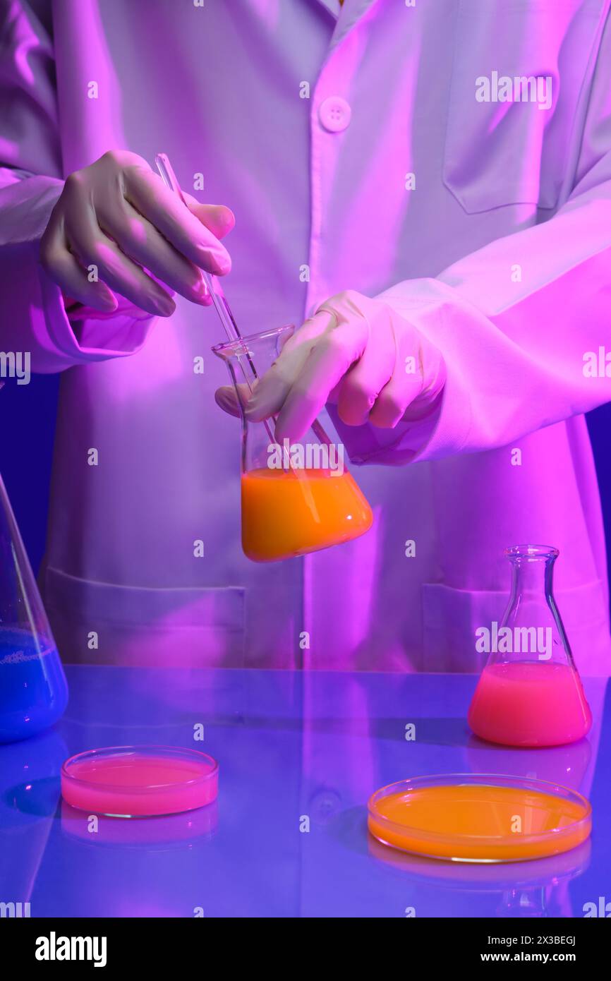 Research science concept with a scientist standing and stirring the ...