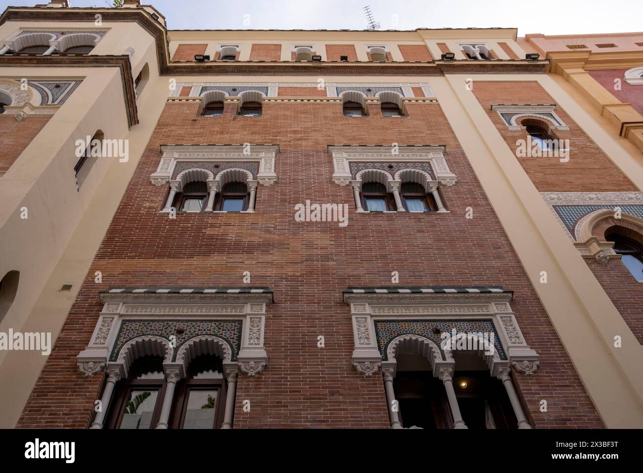 Tall building with a brick facade and symmetrical ornate arched windows ...