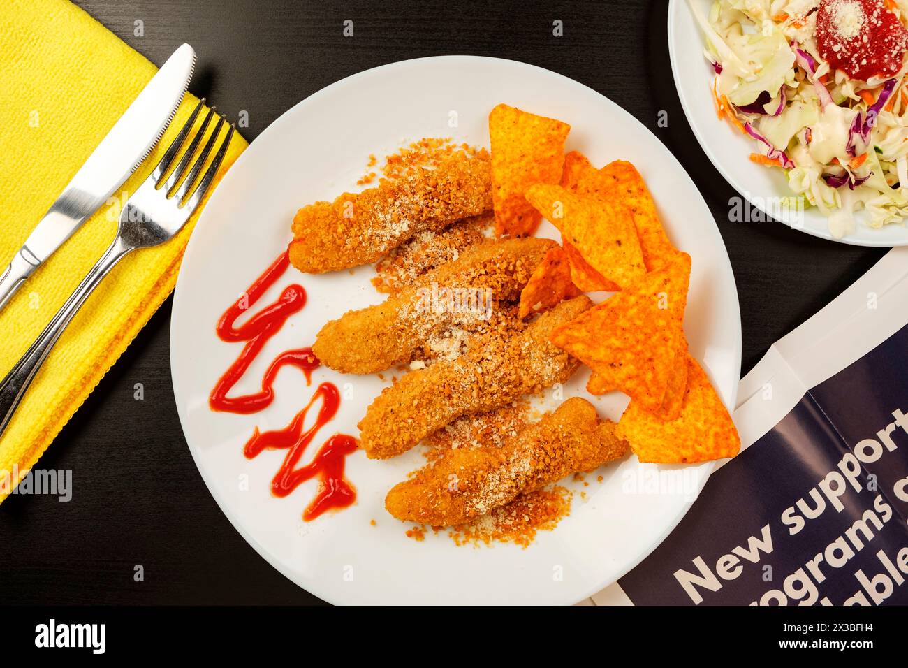 Seasoned and crispy fried chicken strips served with chips, sauce, and ...