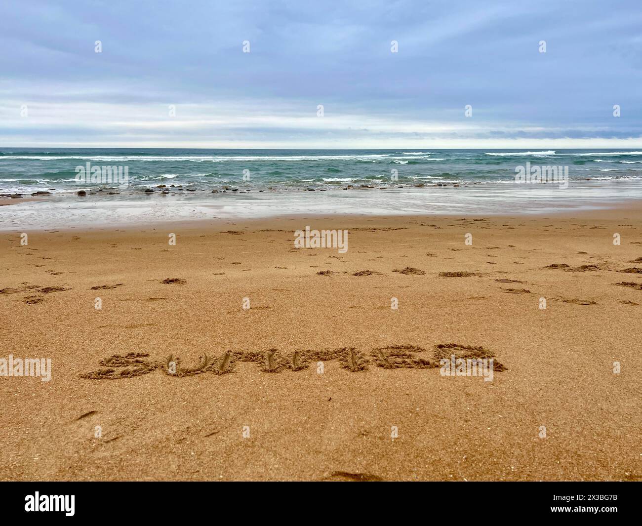 Word Summer handwritten on sandy beach with soft ocean wave on ...