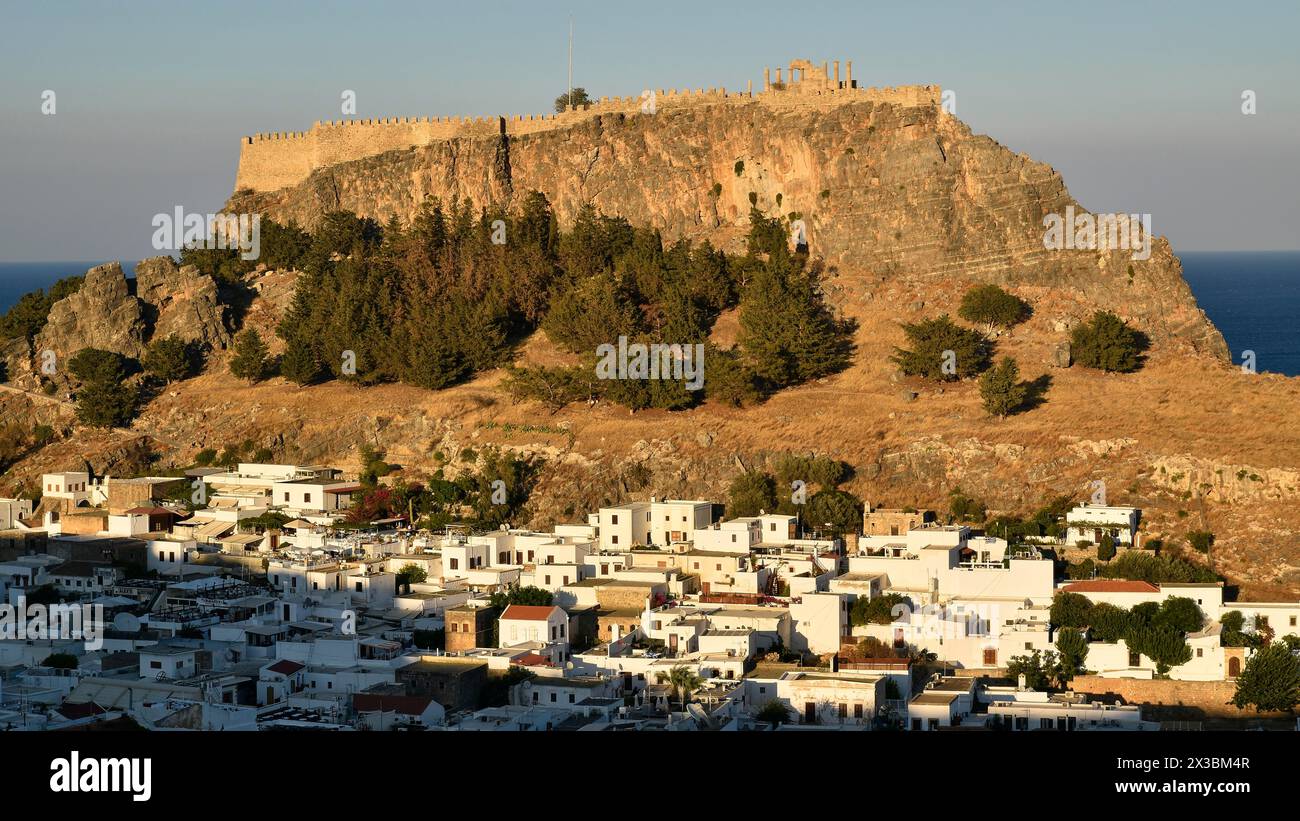 Village and old castle in the golden light of the setting sun, shadows ...