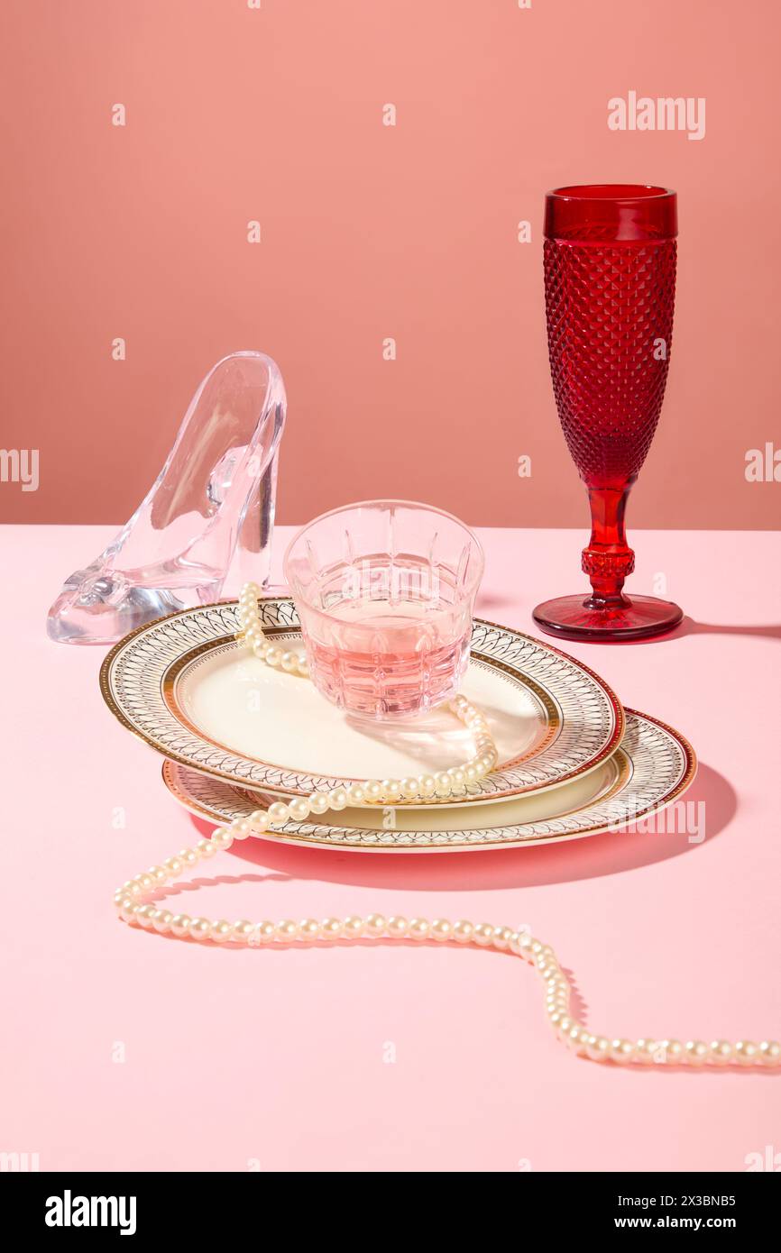 A stack of ceramic dish with a cup of pink liquid placed on top. Red ...