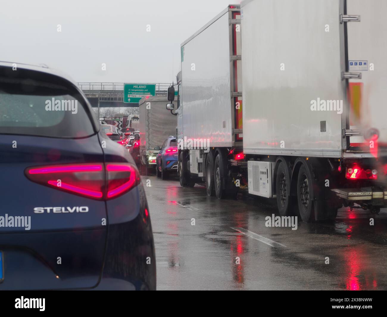 Rainy traffic scene with a convoy of trucks and cars on a wet highway ...