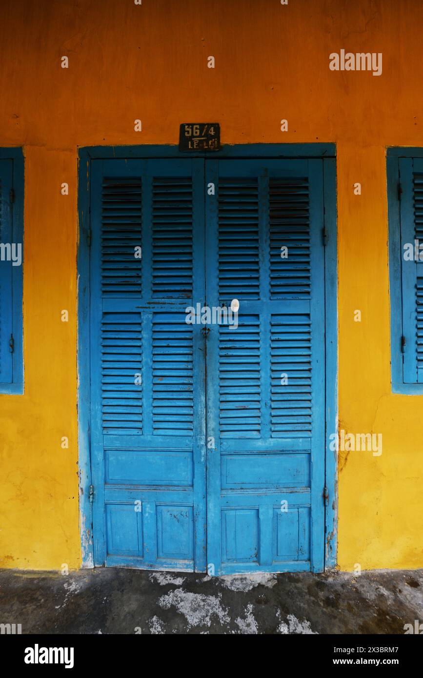 Blue wooden windows in an old yellow building. Old city of Hoi An ...