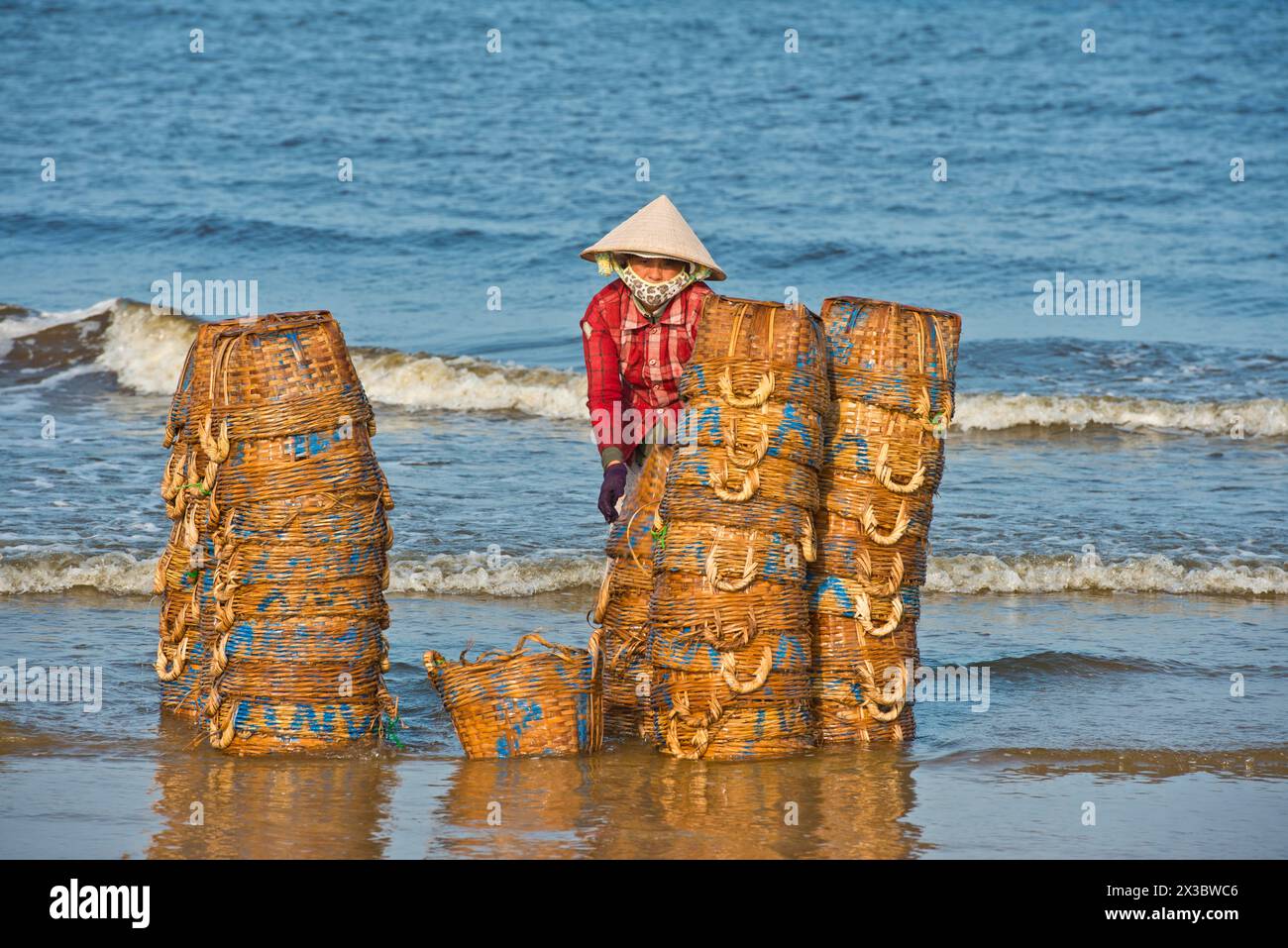 Women with straw hats on the beach cleaning the bast baskets for the ...