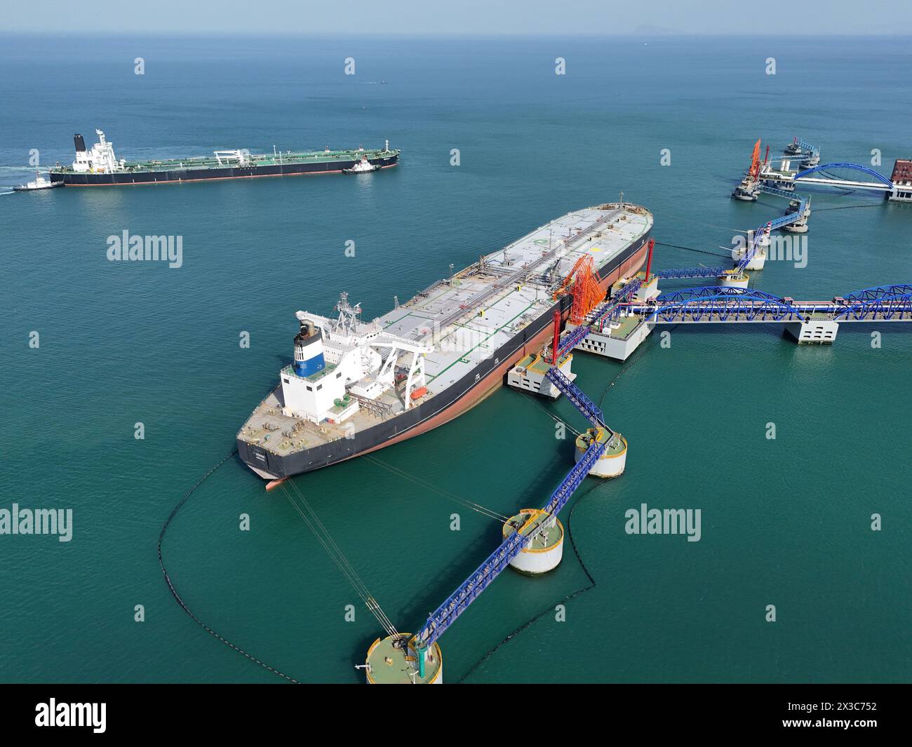 YANTAI, CHINA - APRIL 25, 2024 - A very large oil tanker, assisted by a ...