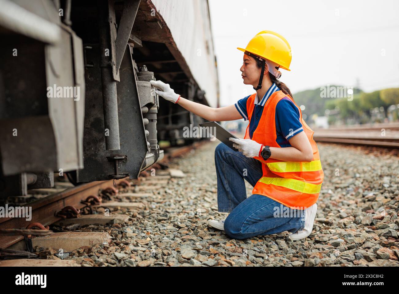 Train locomotive engineer women worker. Young teen Asian working check service maintenance train ...
