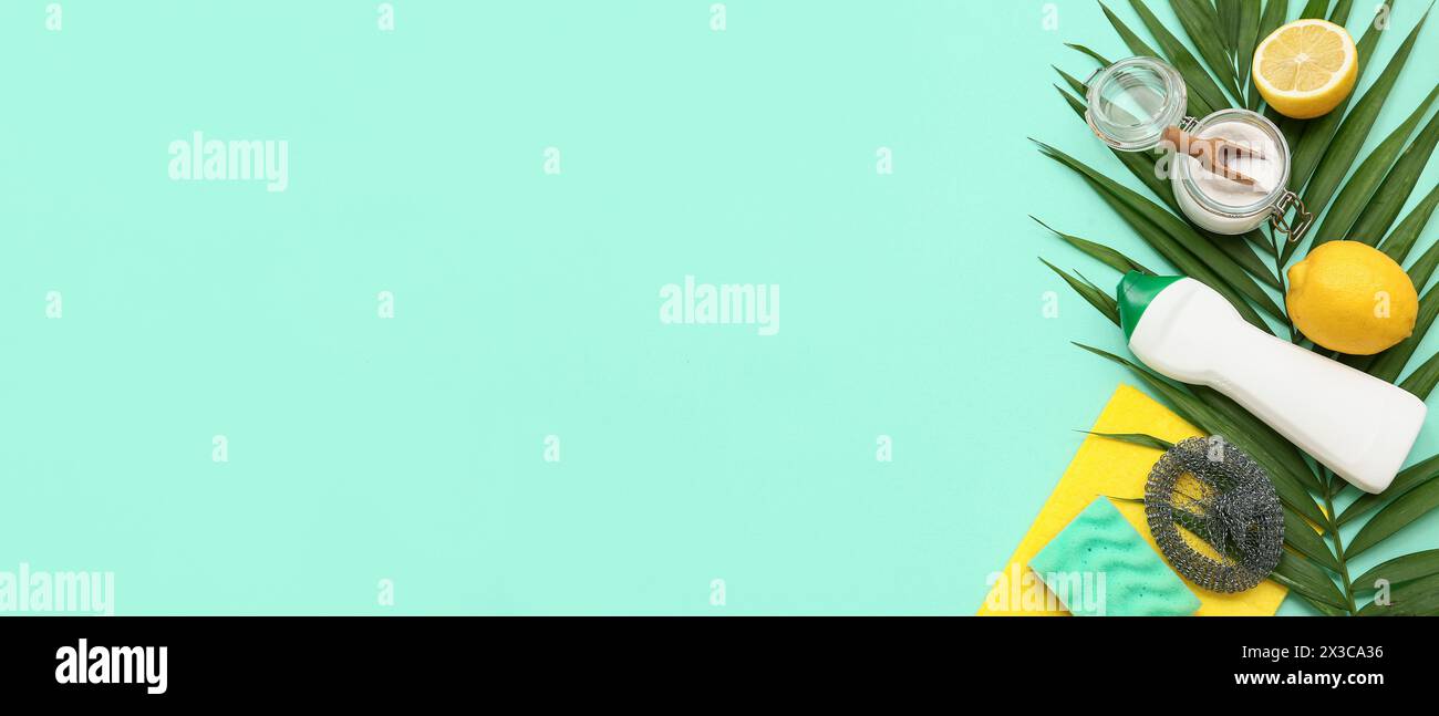 Soda with lemon, bottle of detergent and cleaning supplies on turquoise ...