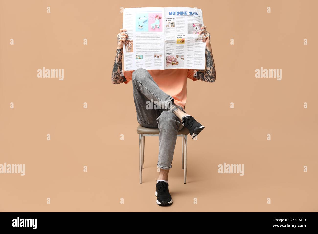 Man with newspaper on beige background Stock Photo - Alamy