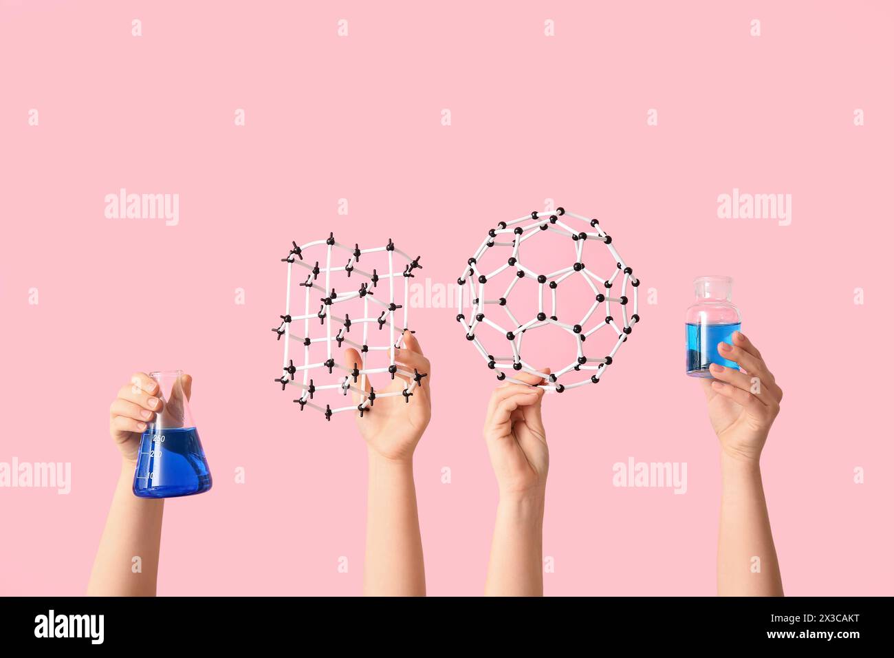 Female hands holding molecular models with filled flask and bottle on ...