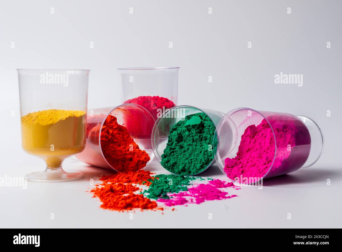 Colorful holi powder in a glass container isolated on white background ...