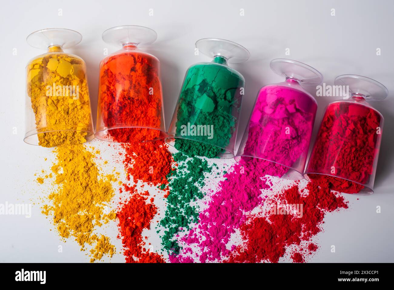 Colorful holi powder in a plastic containers on white background. Top ...