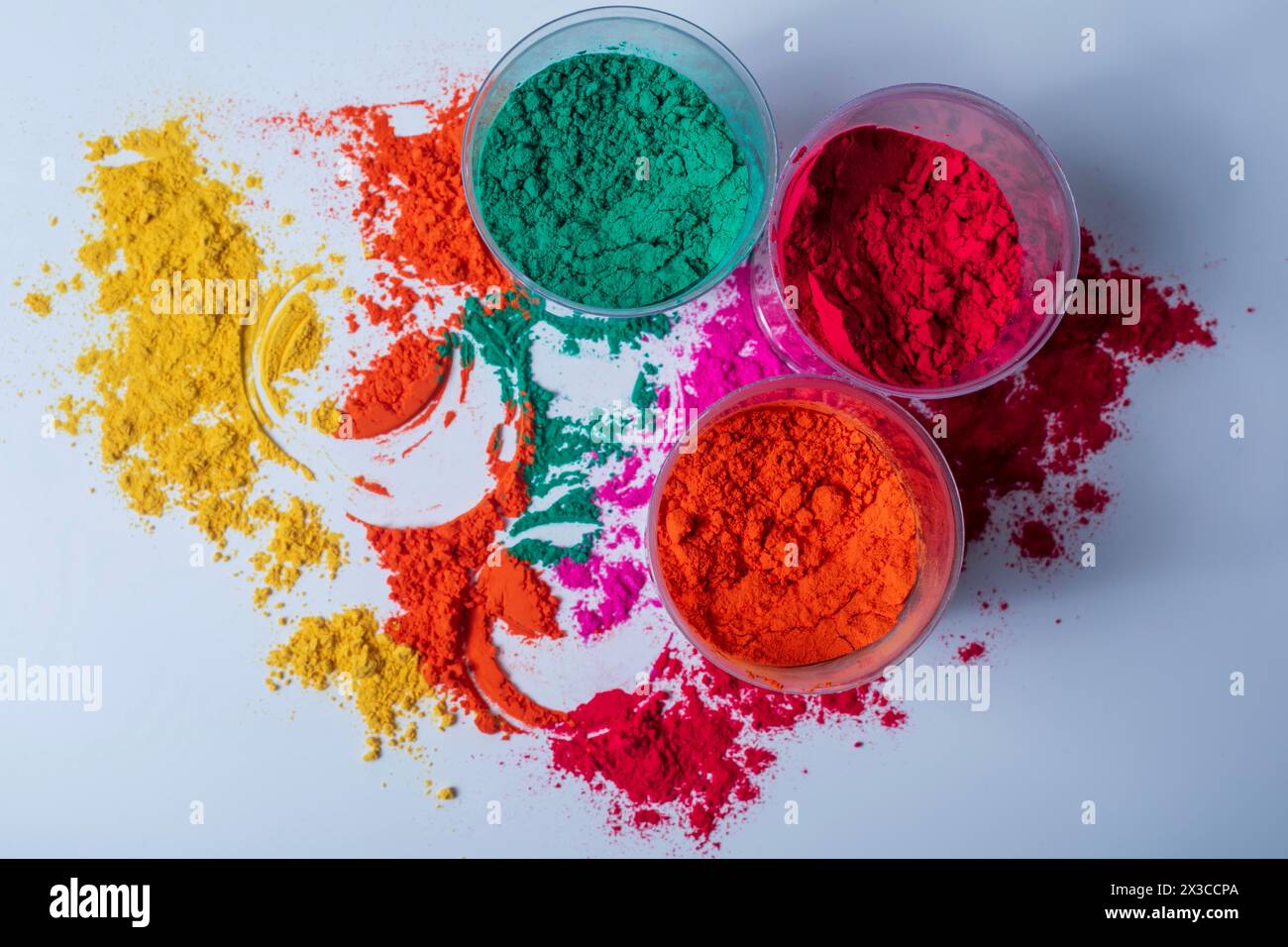 Colorful holi powder in plastic containers on a white background. Top ...