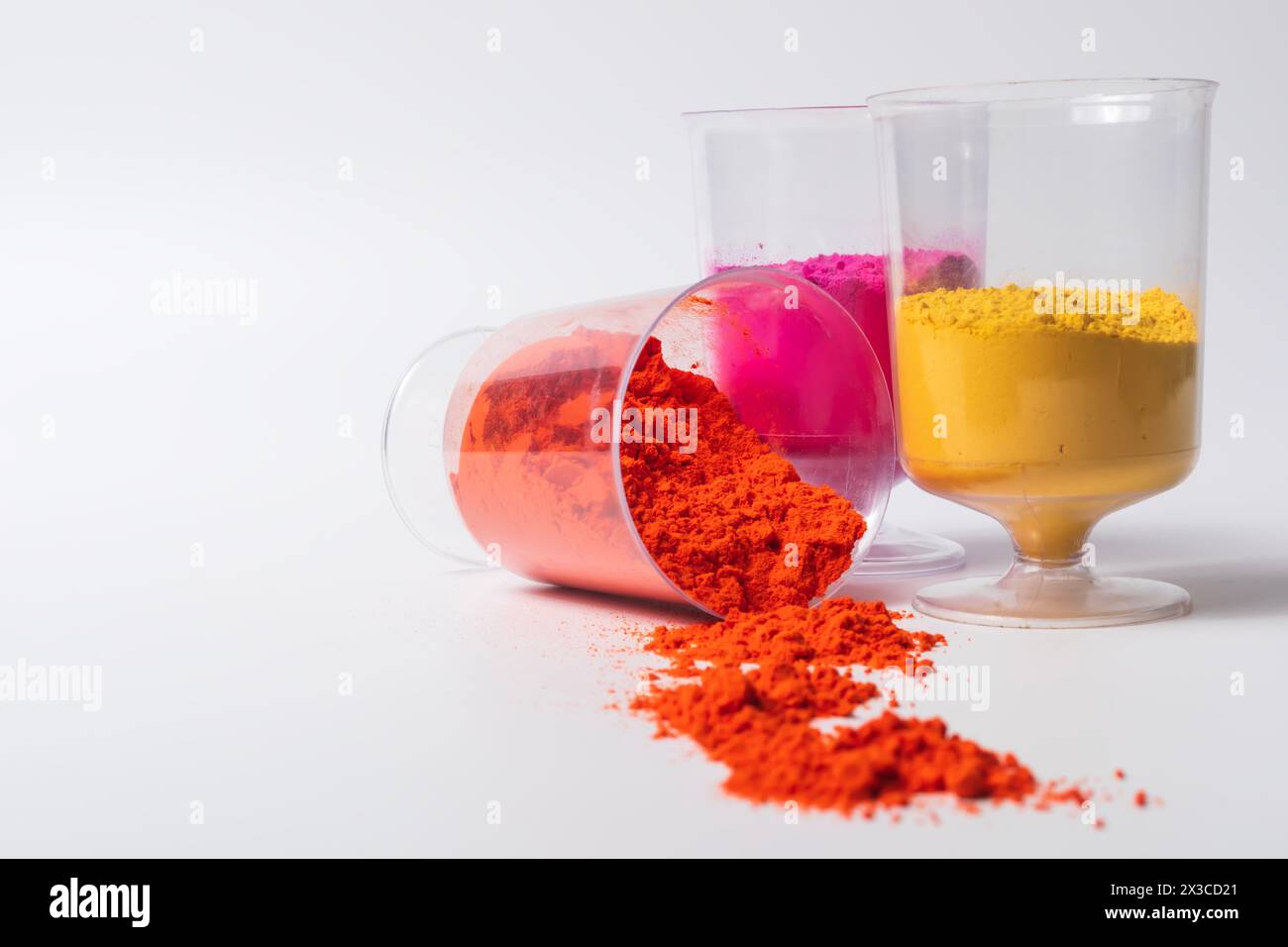 Colorful holi powder in measuring cups on a white background with copy ...