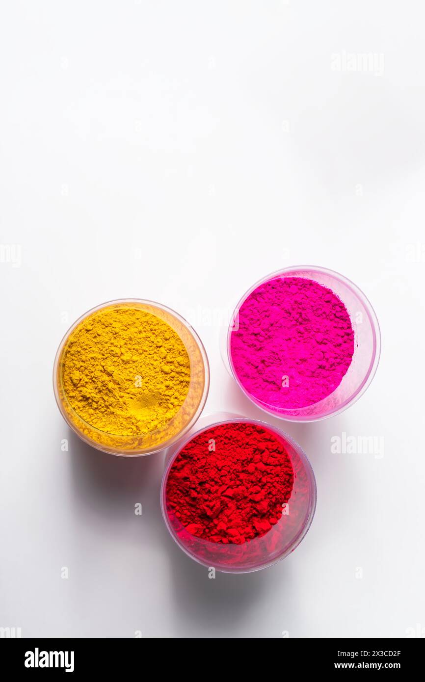 Colorful holi powder in plastic containers isolated on white background ...