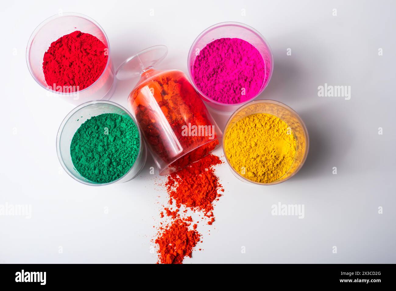 Colorful holi powder in plastic containers isolated on white background ...
