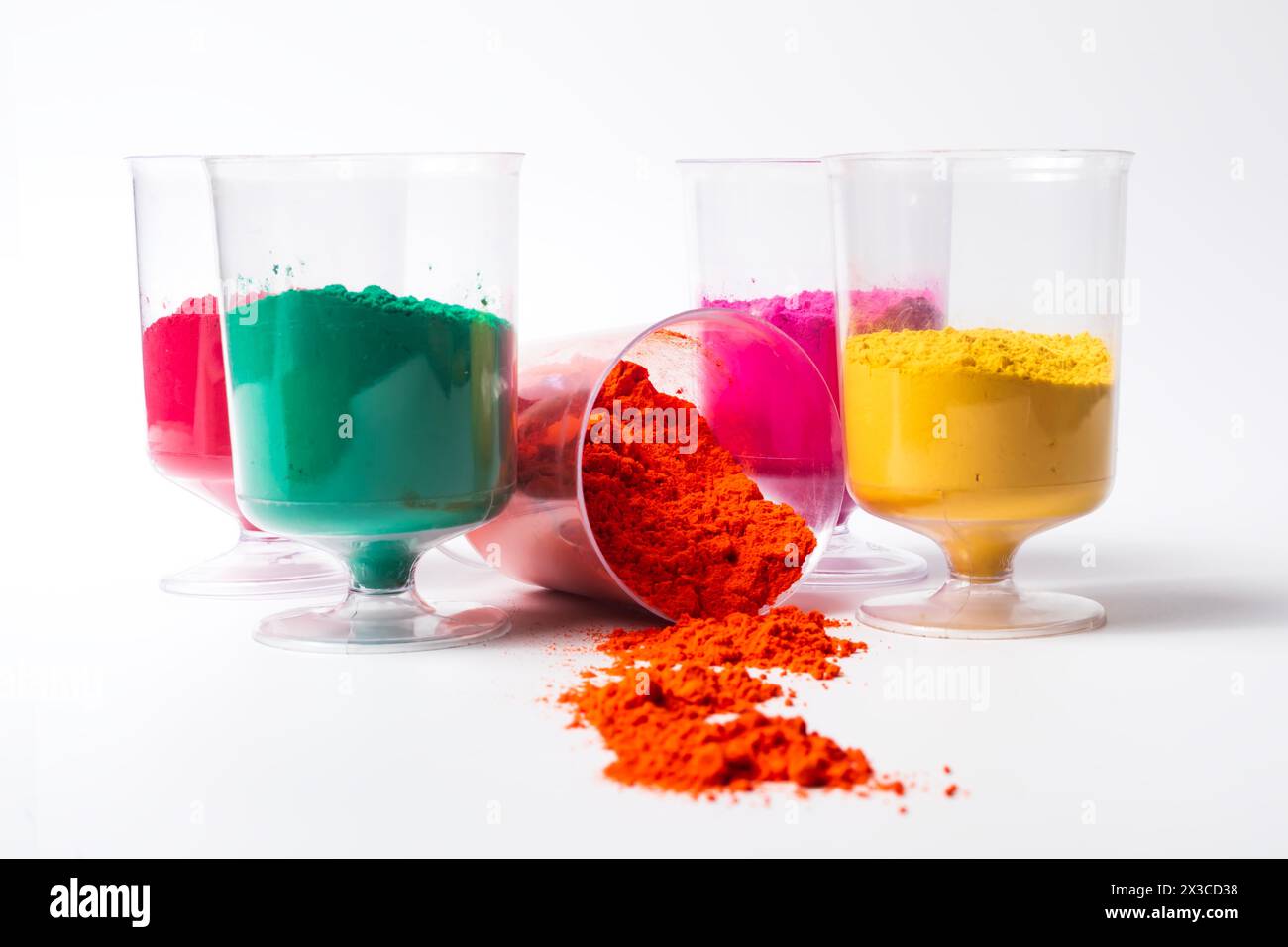 Colorful holi powder in measuring cups on a white background with copy ...
