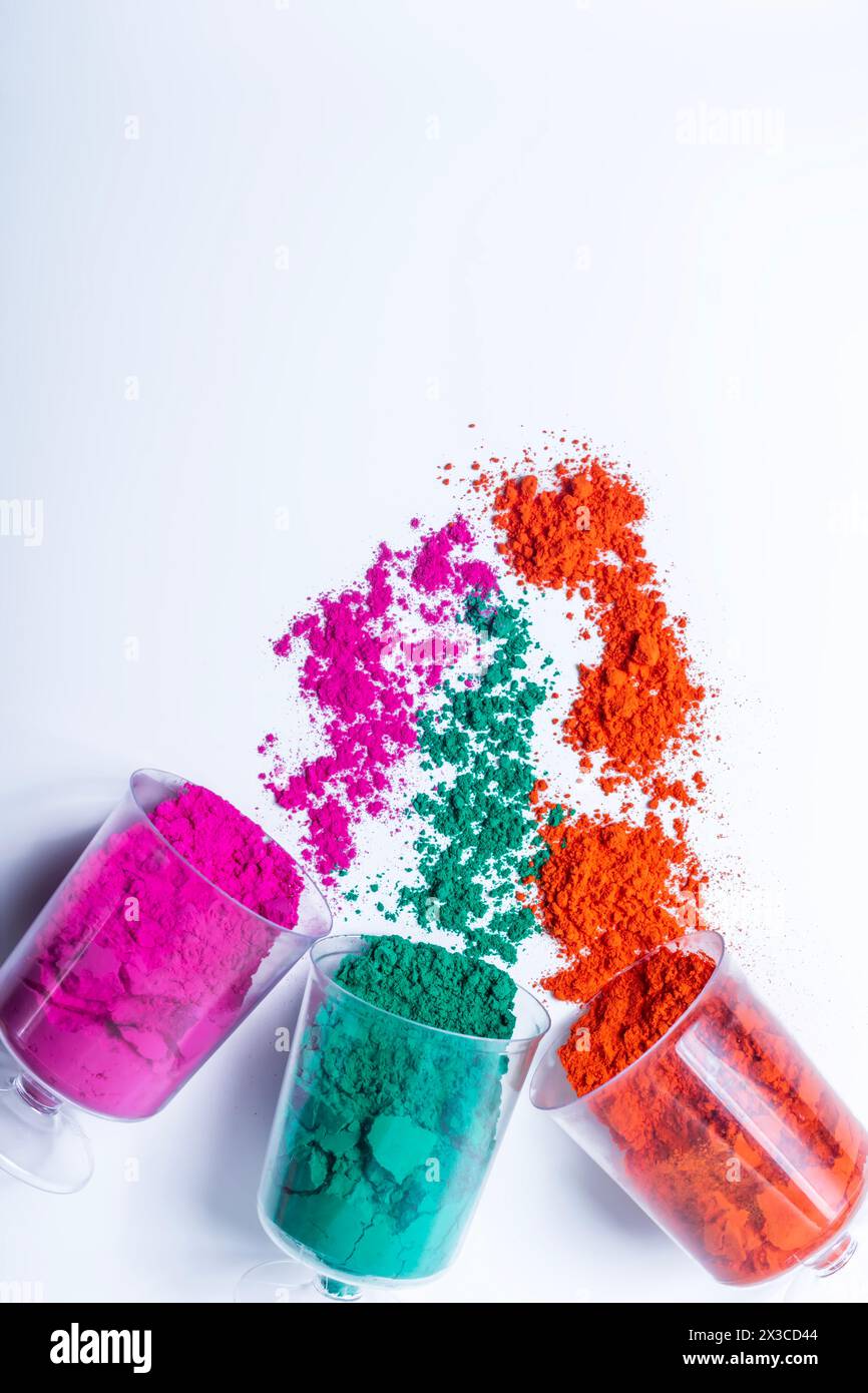 Colorful holi powder in a plastic containers on white background. Top ...