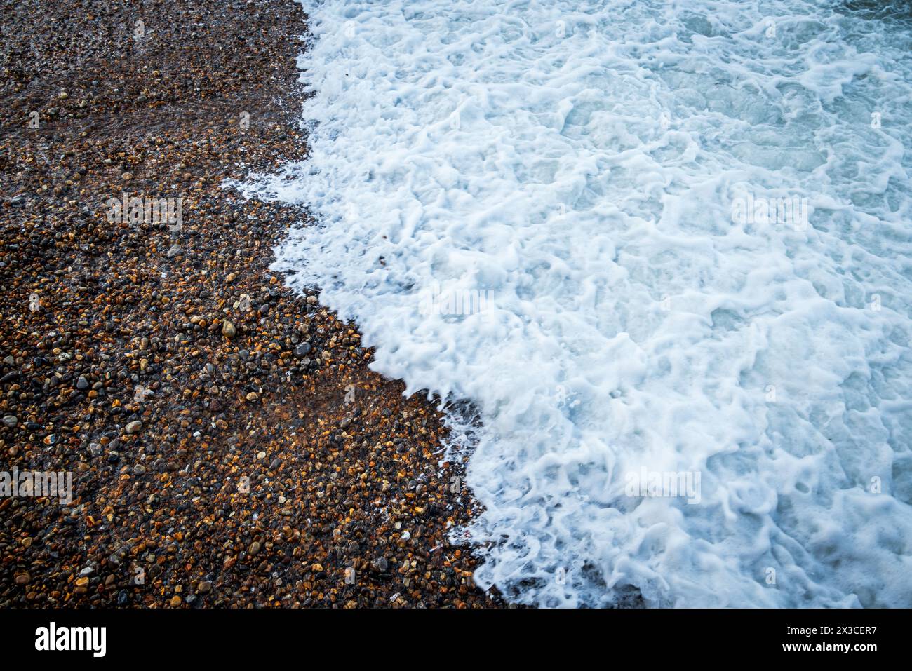 Splashes from tidal waves washing the small pebbles 2 Stock Photo - Alamy