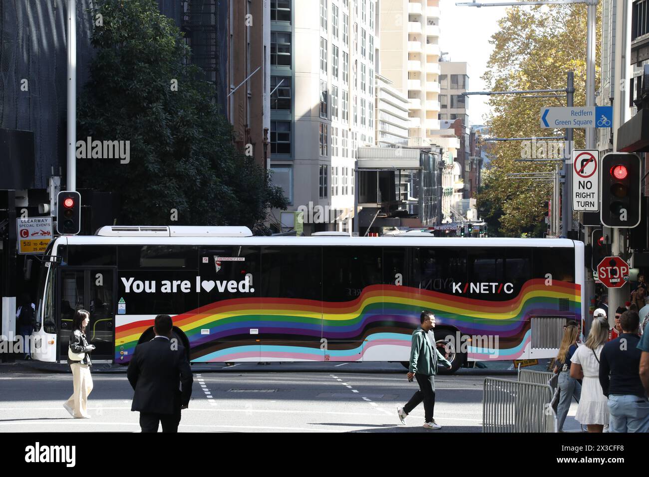 A coach with a progress pride flag is used to block off a street to ...