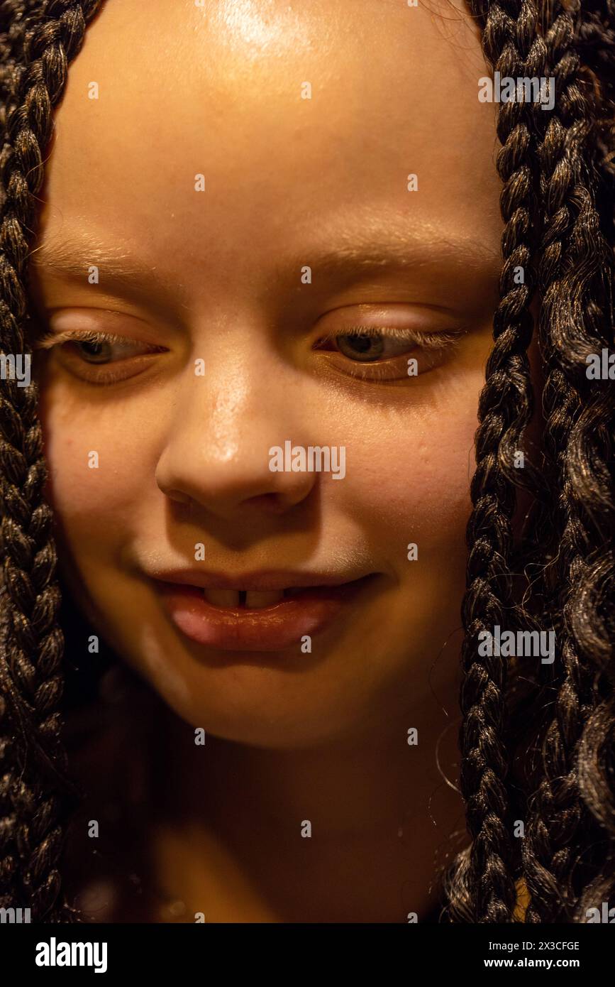 This image is a tender portrait of a child with eyes closed and a ...