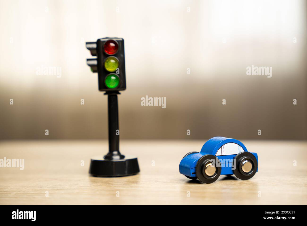 A toy blue car near a traffic light on the table. Traffic and driving ...