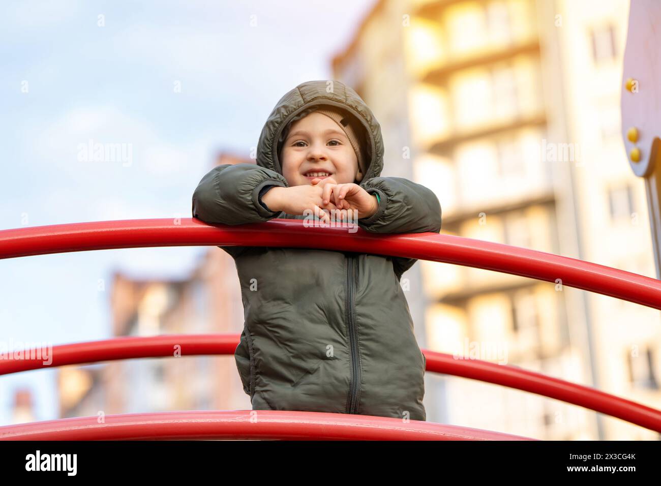Happy smiling three year old toddler boy on the playground looking into ...