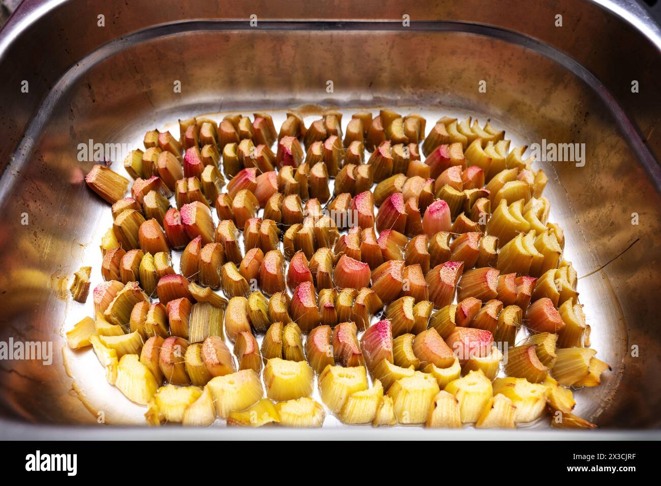 Diced rhubarb in a metal bowl prepared for cooking in the oven, healthy ...