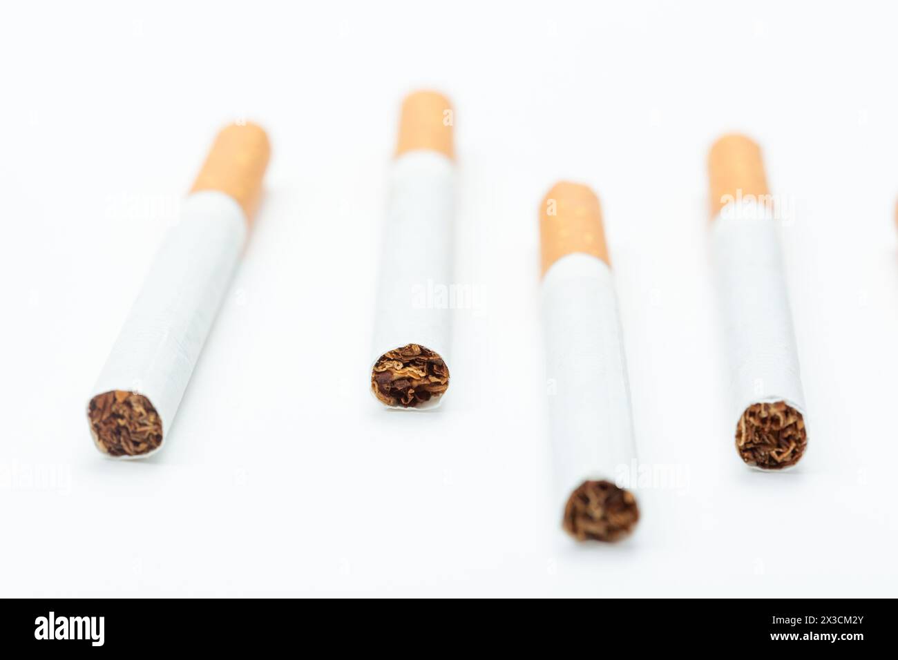 Four cigarettes on a white background Stock Photo - Alamy