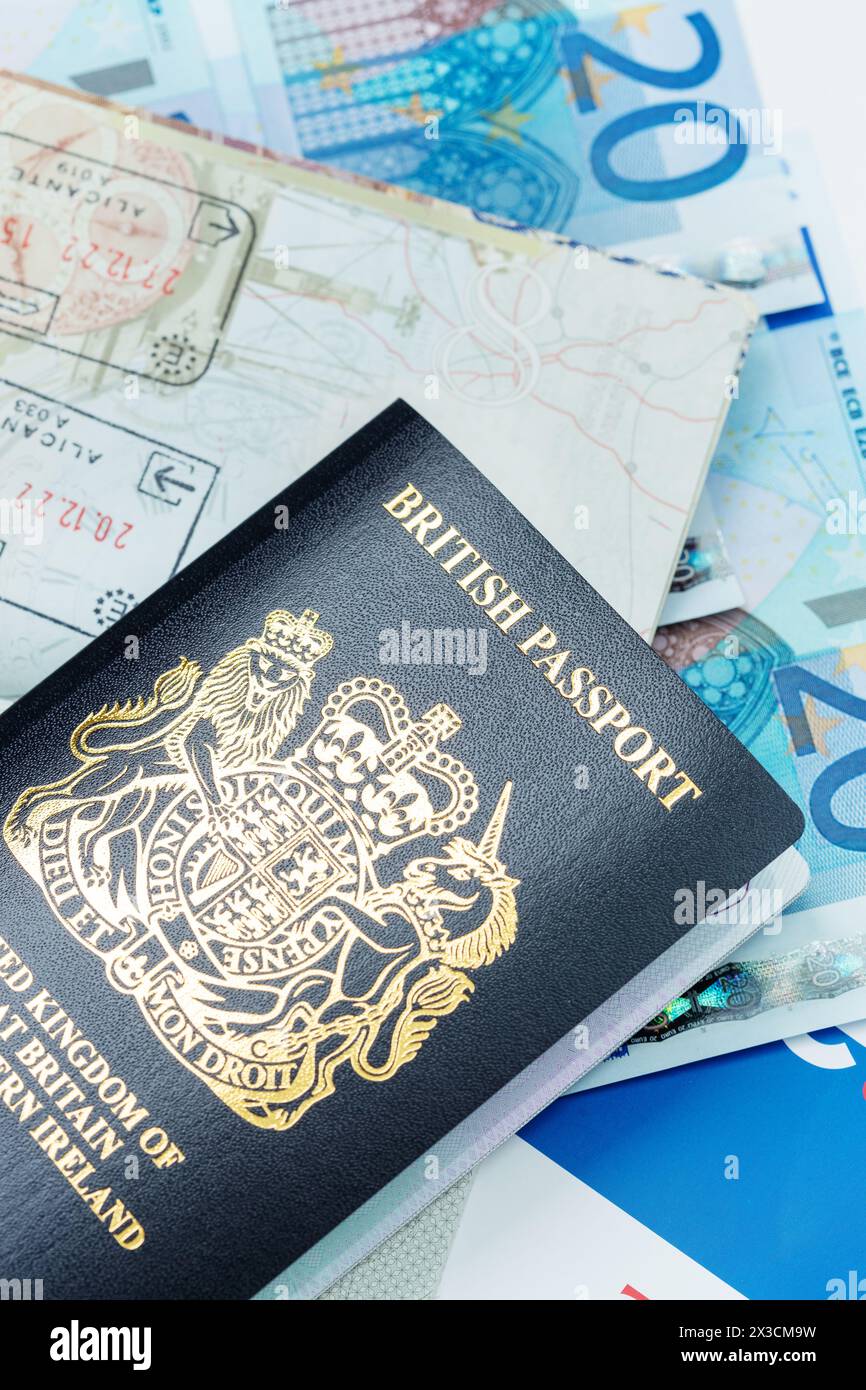 Close up a new blue british passport with Euro notes in the background ...