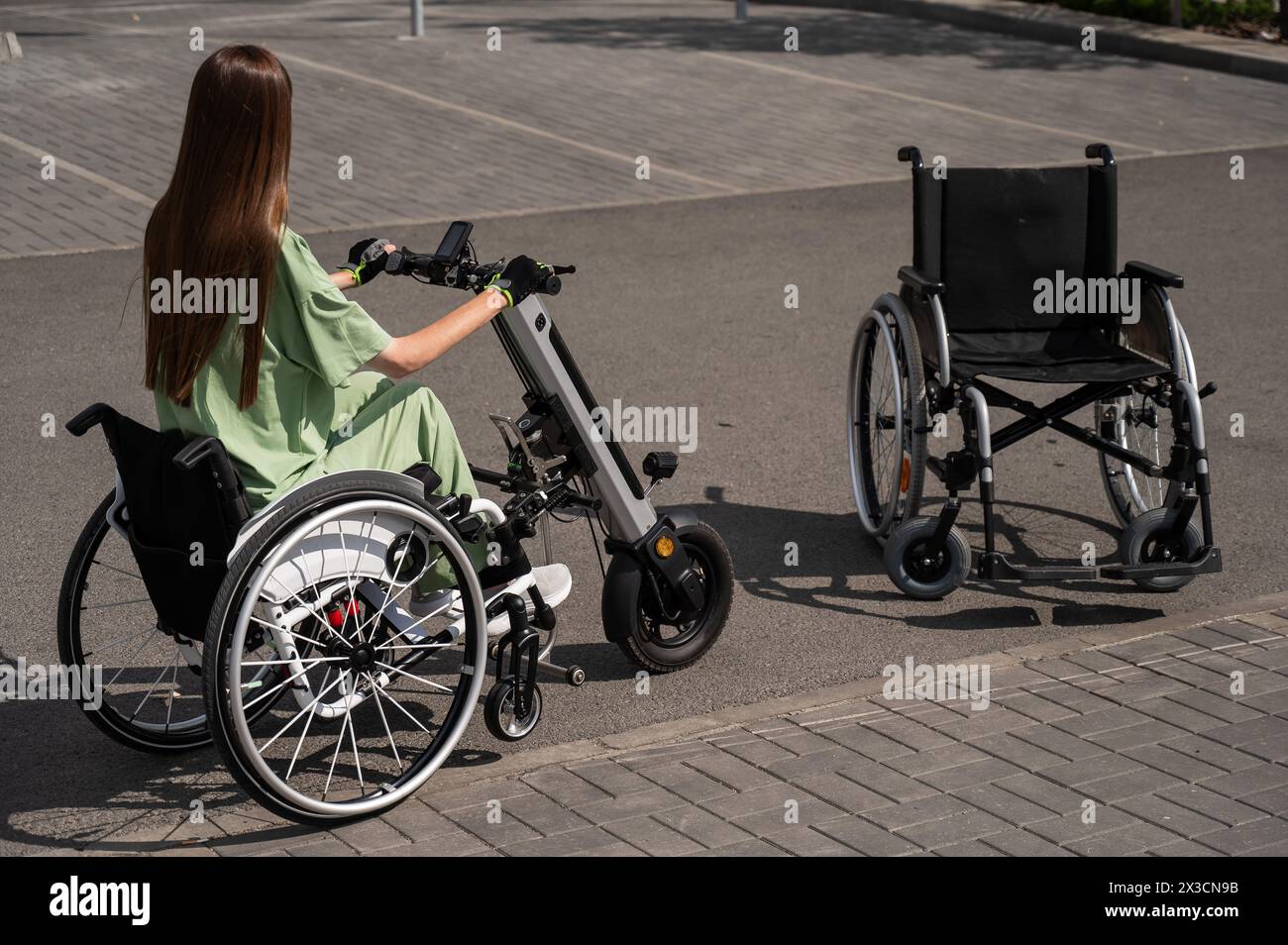 Woman in wheelchair with assistive device for manual control next to ...