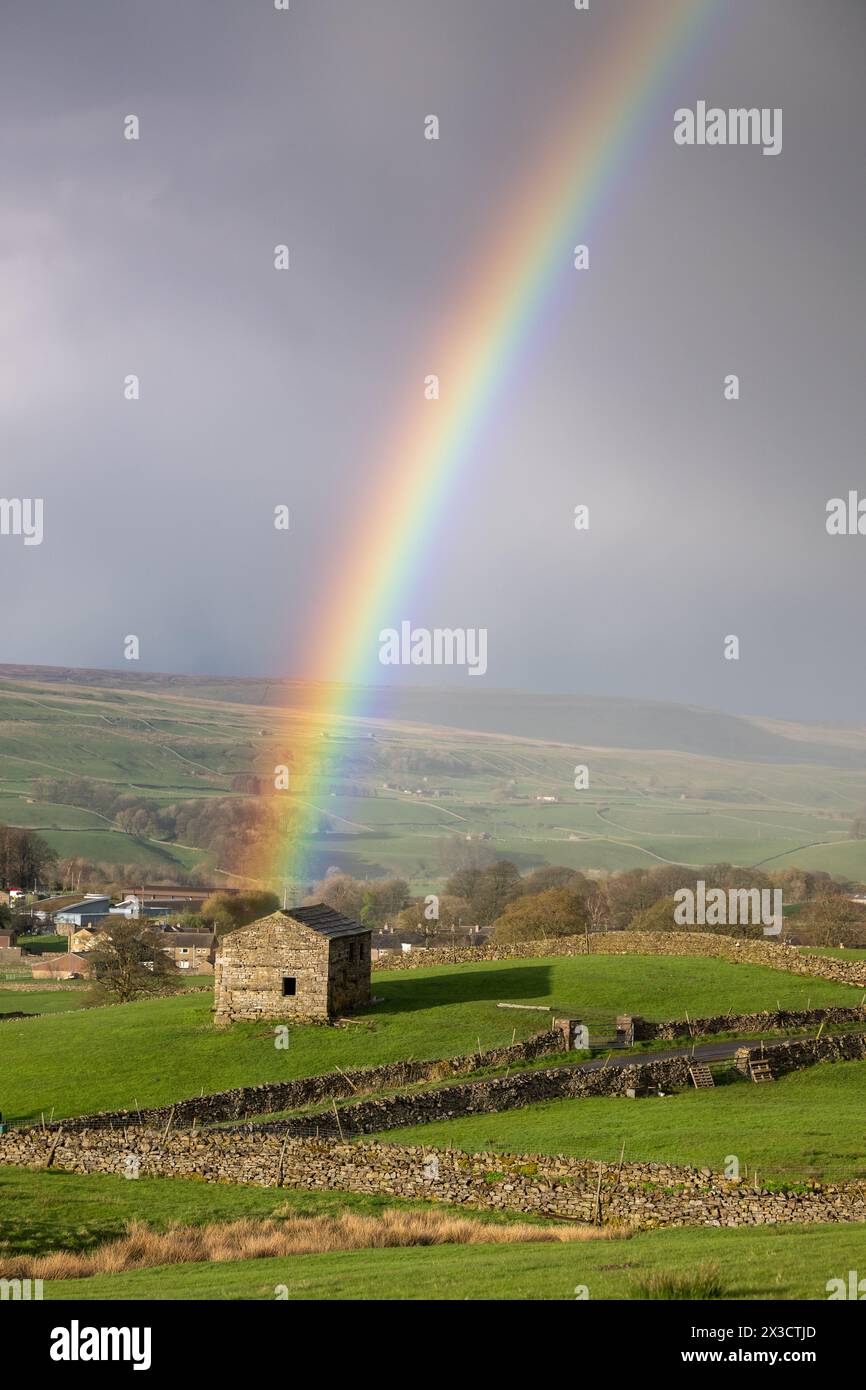 Old stone barn in the Yorkshire Dales at the end of a rainbow during a ...