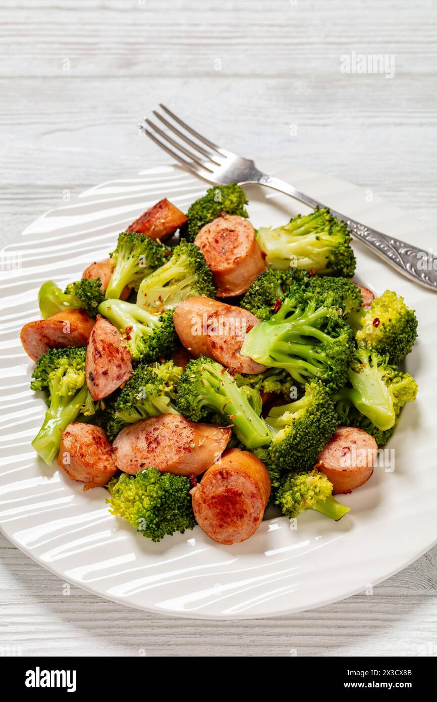 pan seared juicy sausage and crispy tender broccoli on white plate with ...