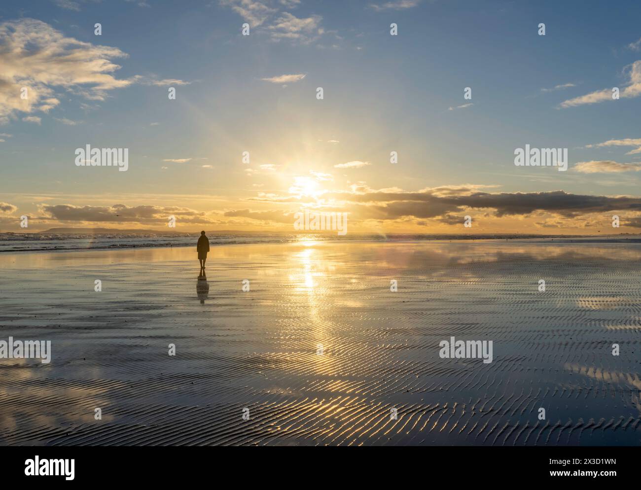 A lone person walks towards sunset at the magnificent West Wittering ...