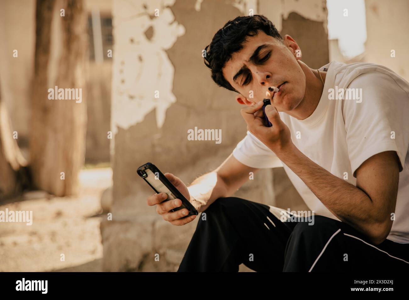 Boy smoking a marijuana cigarette in his neighborhood Stock Photo - Alamy