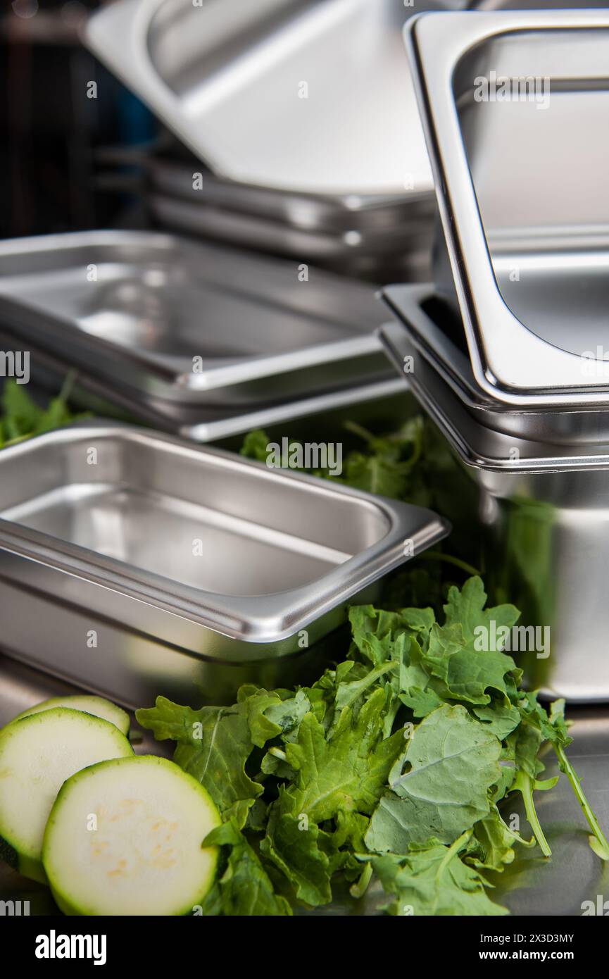 Professional kitchen with stacked stainless steel pans and greens Stock ...