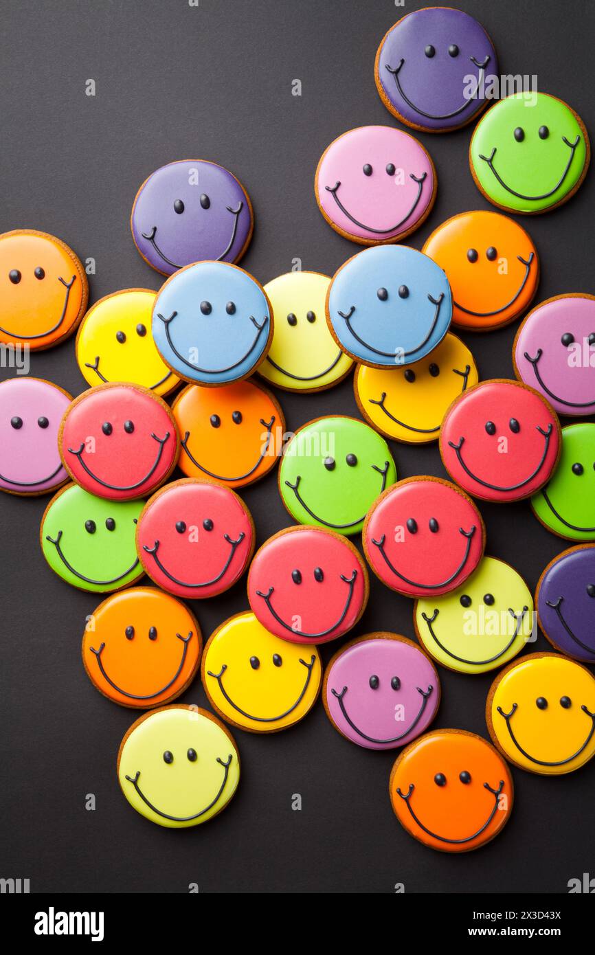 Colorful smiley face gingerbread cookies on a dark background. Flat lay ...