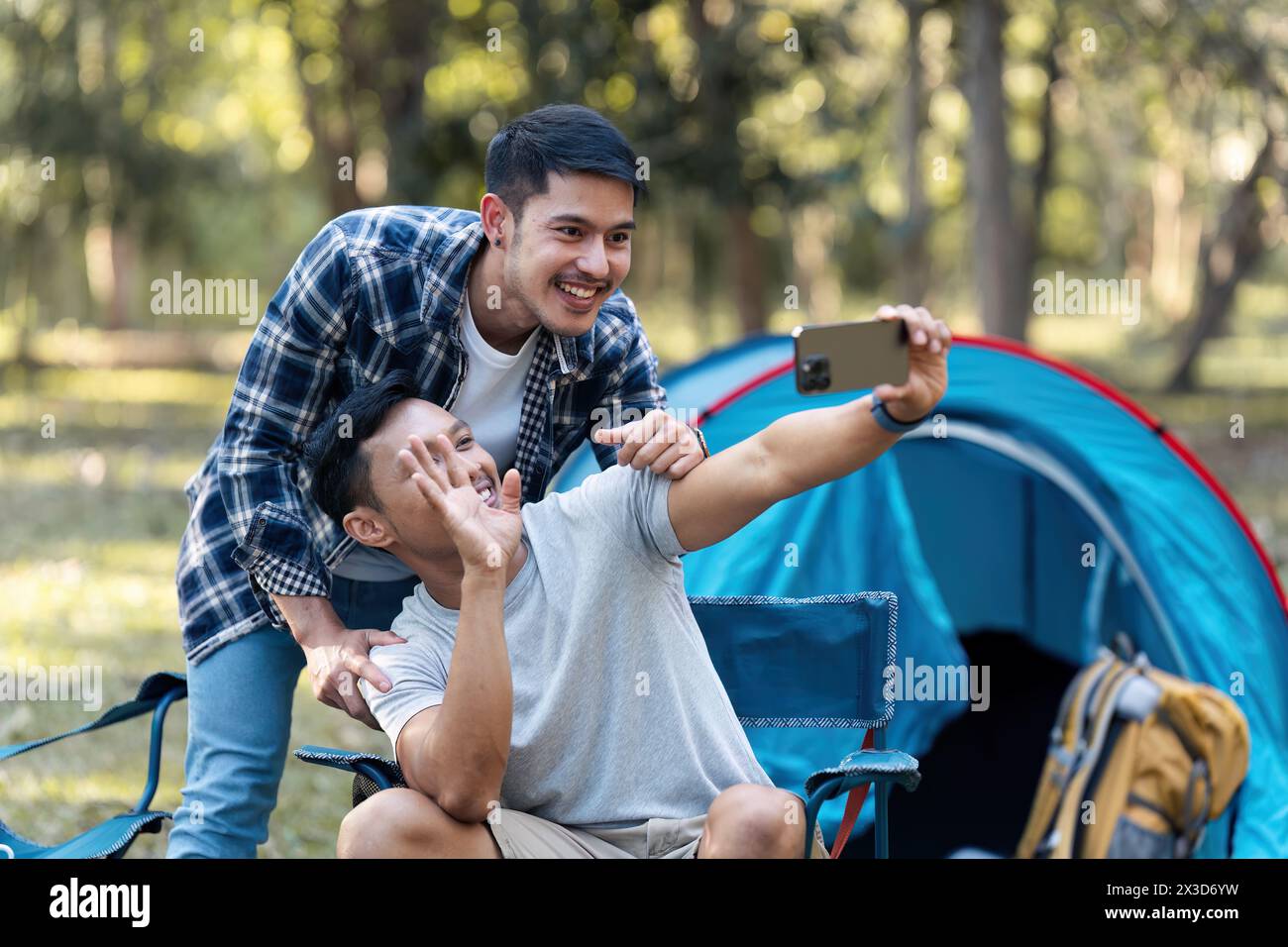 LGBTQIA Gay couple camping together in woods for holidays and relax ...