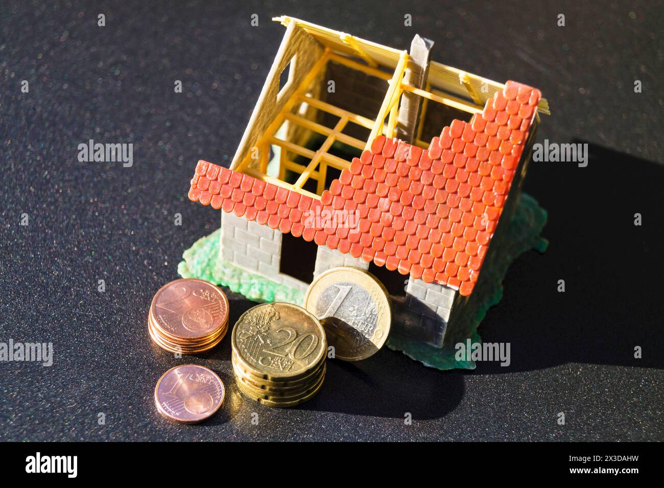 unfinished model house and Euro coins, symbolising the rise in house ...