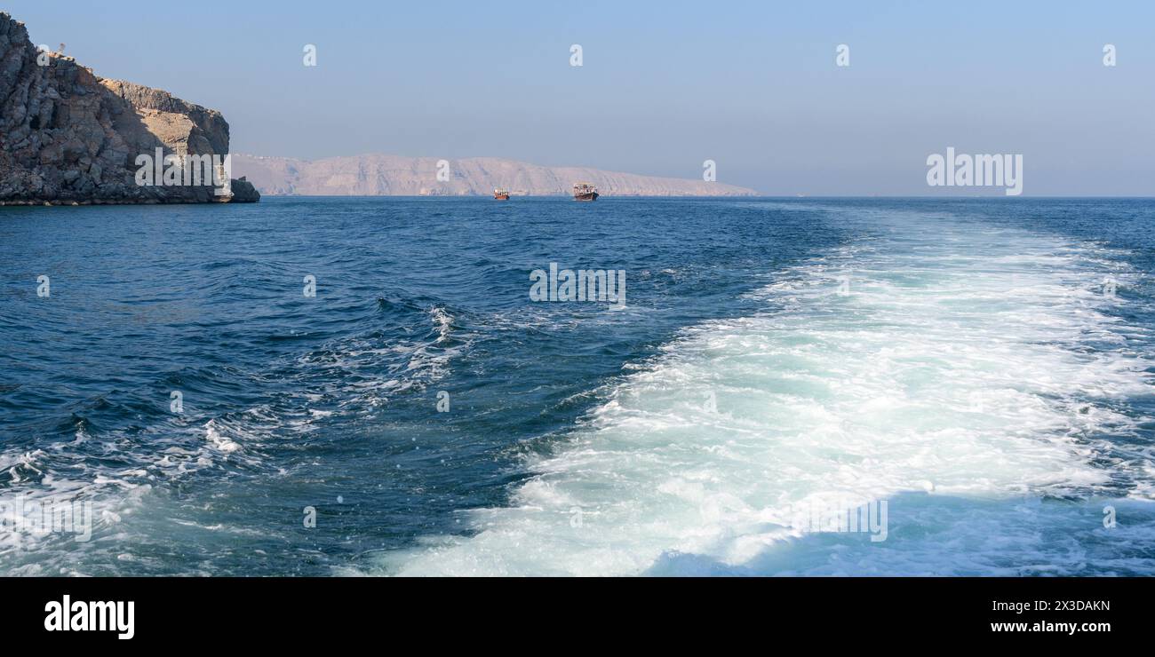 Tourist boats navigate the serene fjords of Khasab, where the sea meets ...