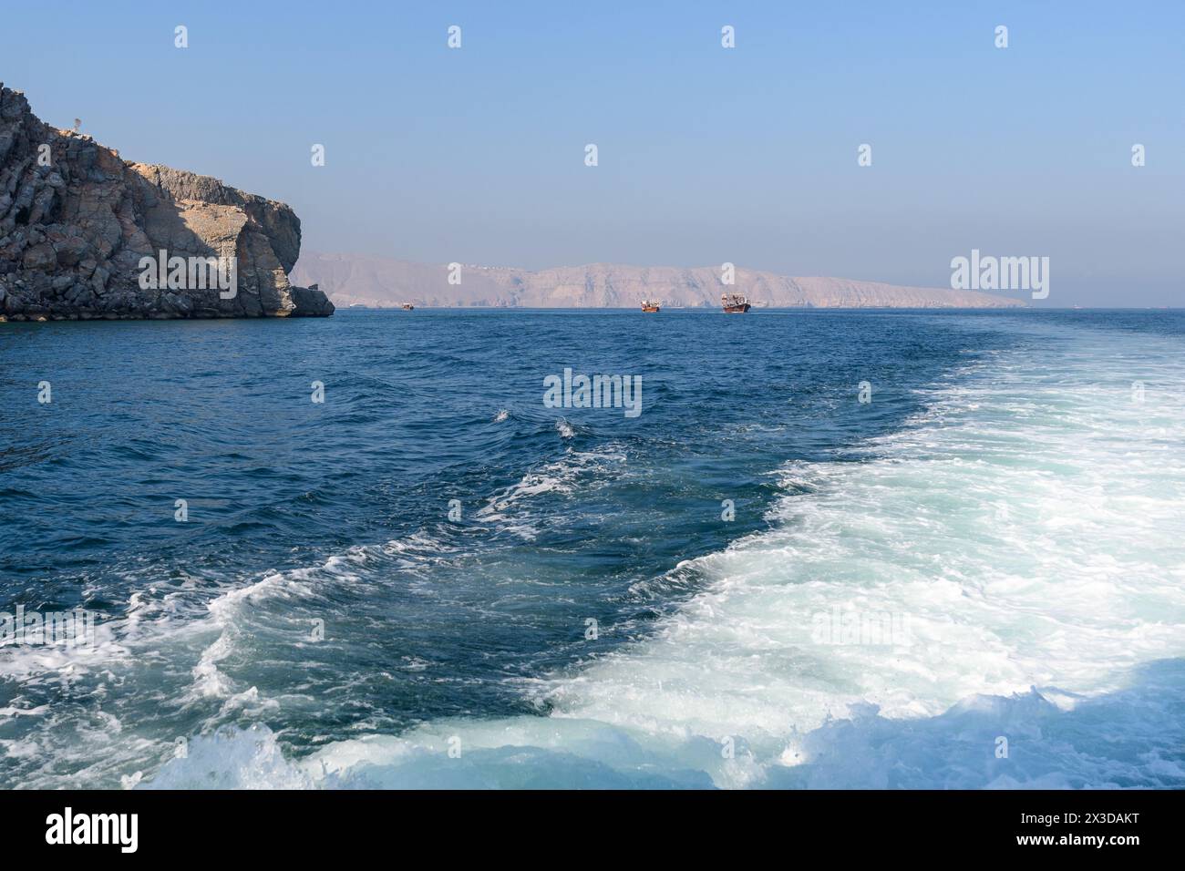 Tourist boats navigate the serene fjords of Khasab, where the sea meets ...