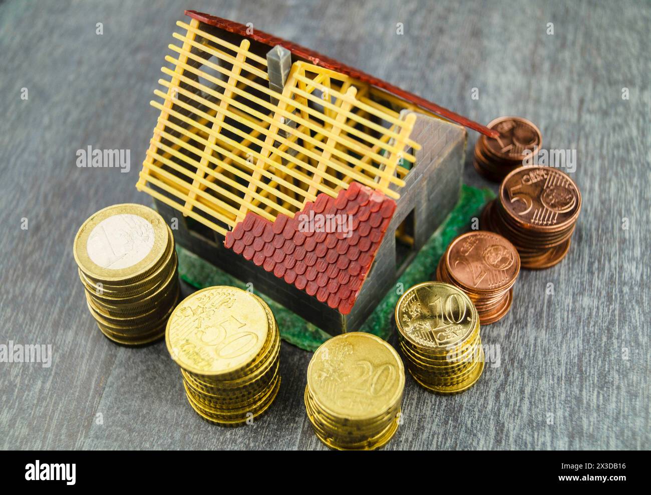 unfinished model house and pile of money, symbolising the rise in house ...