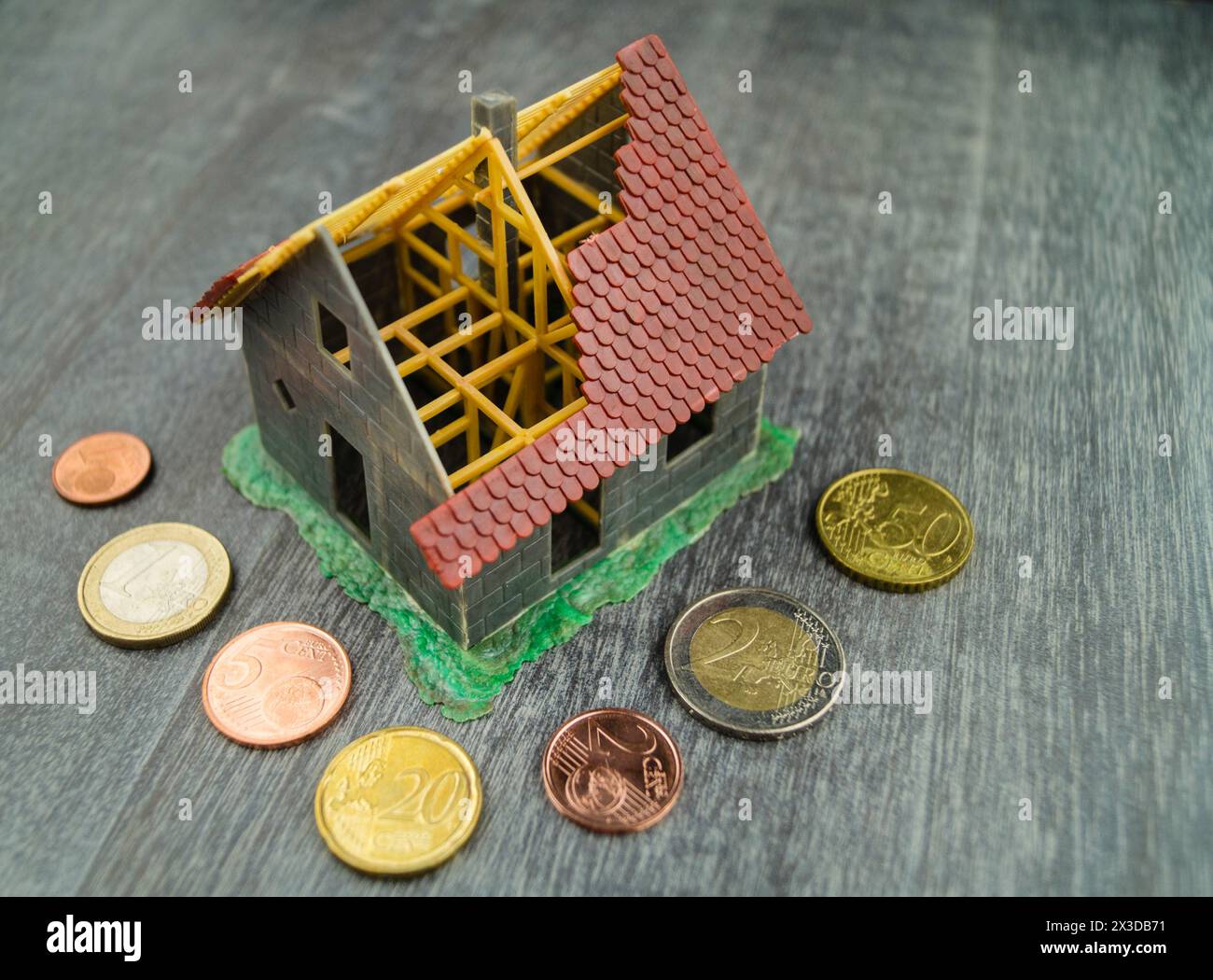 unfinished model house and pile of money, symbolising the rise in house ...