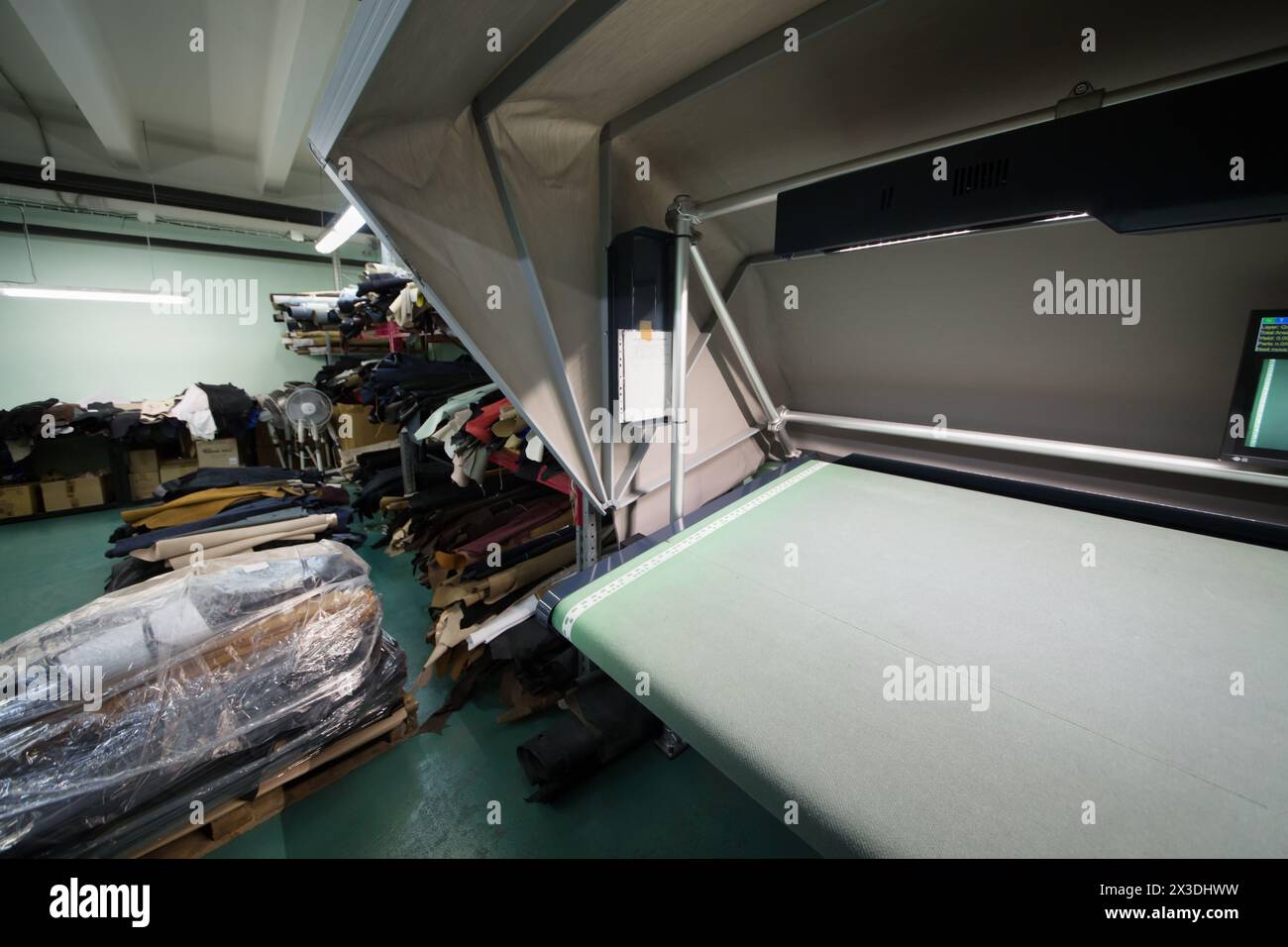 Empty workshop with leather rolls and suede and special cutting machine ...