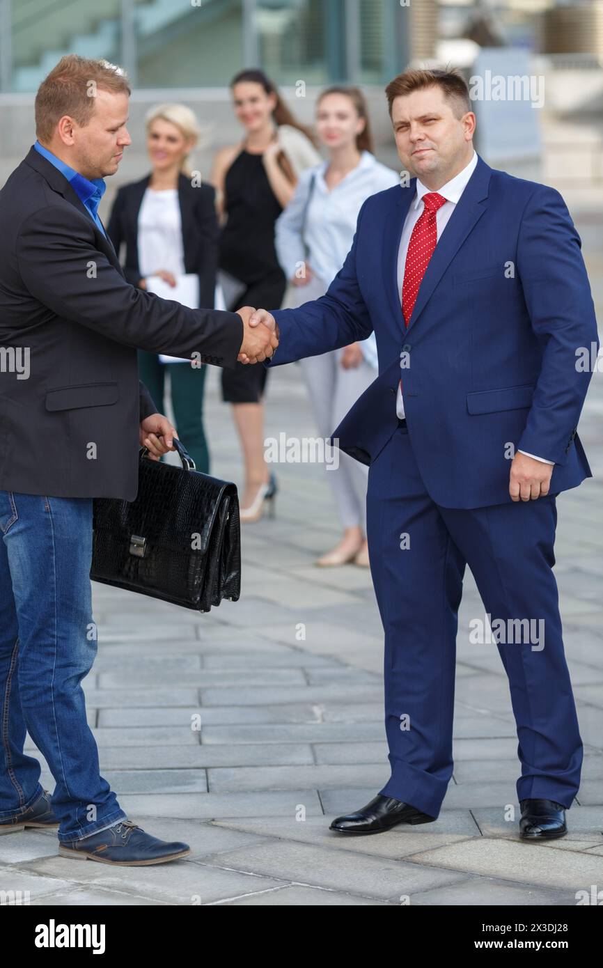 two successful mature business partners at work, both are shaking hands ...