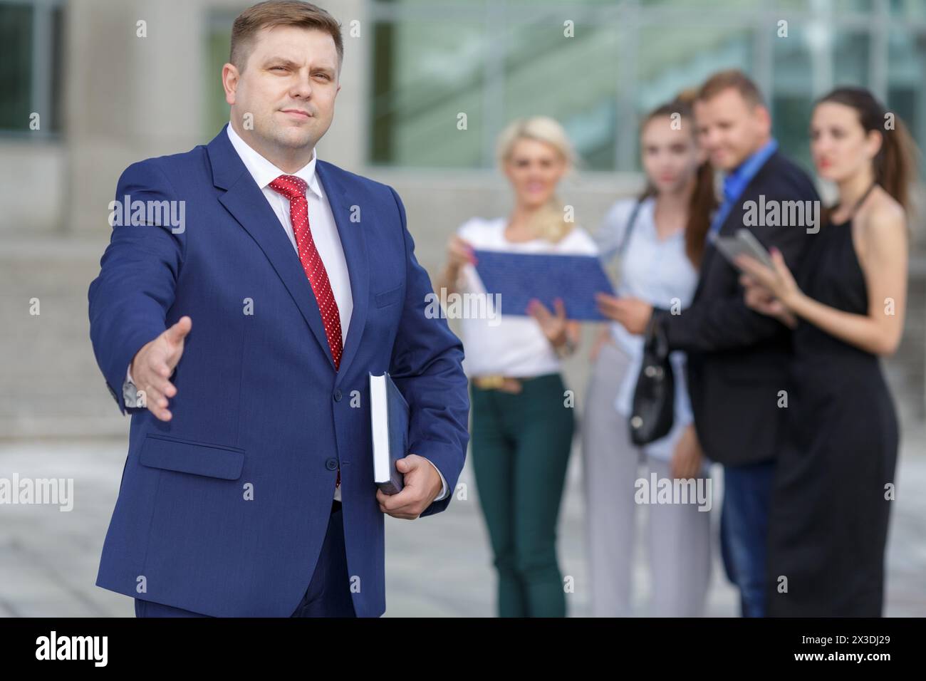 well dressed business team leader and four co-workers in background ...