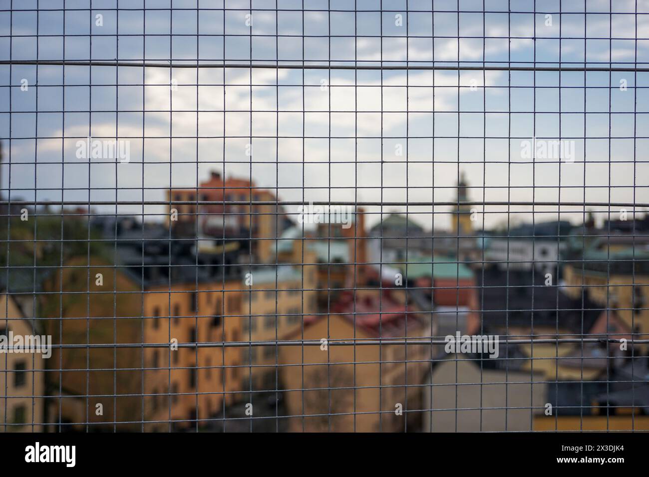View of a city behind a fence Stock Photo - Alamy