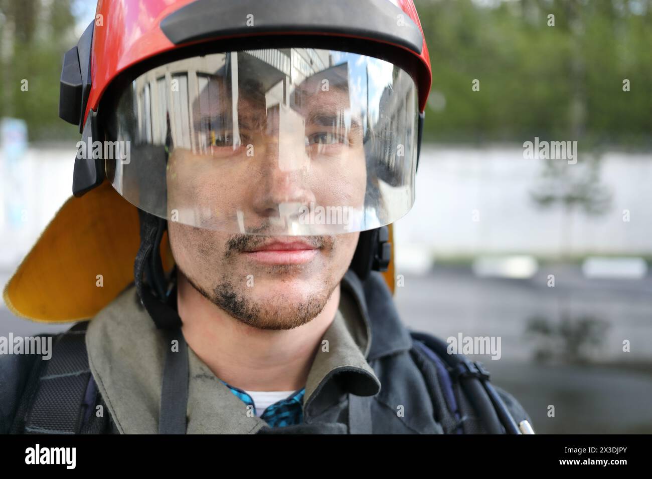 Portrait of fireman wearing fire fighter turnouts and red fire helmet ...