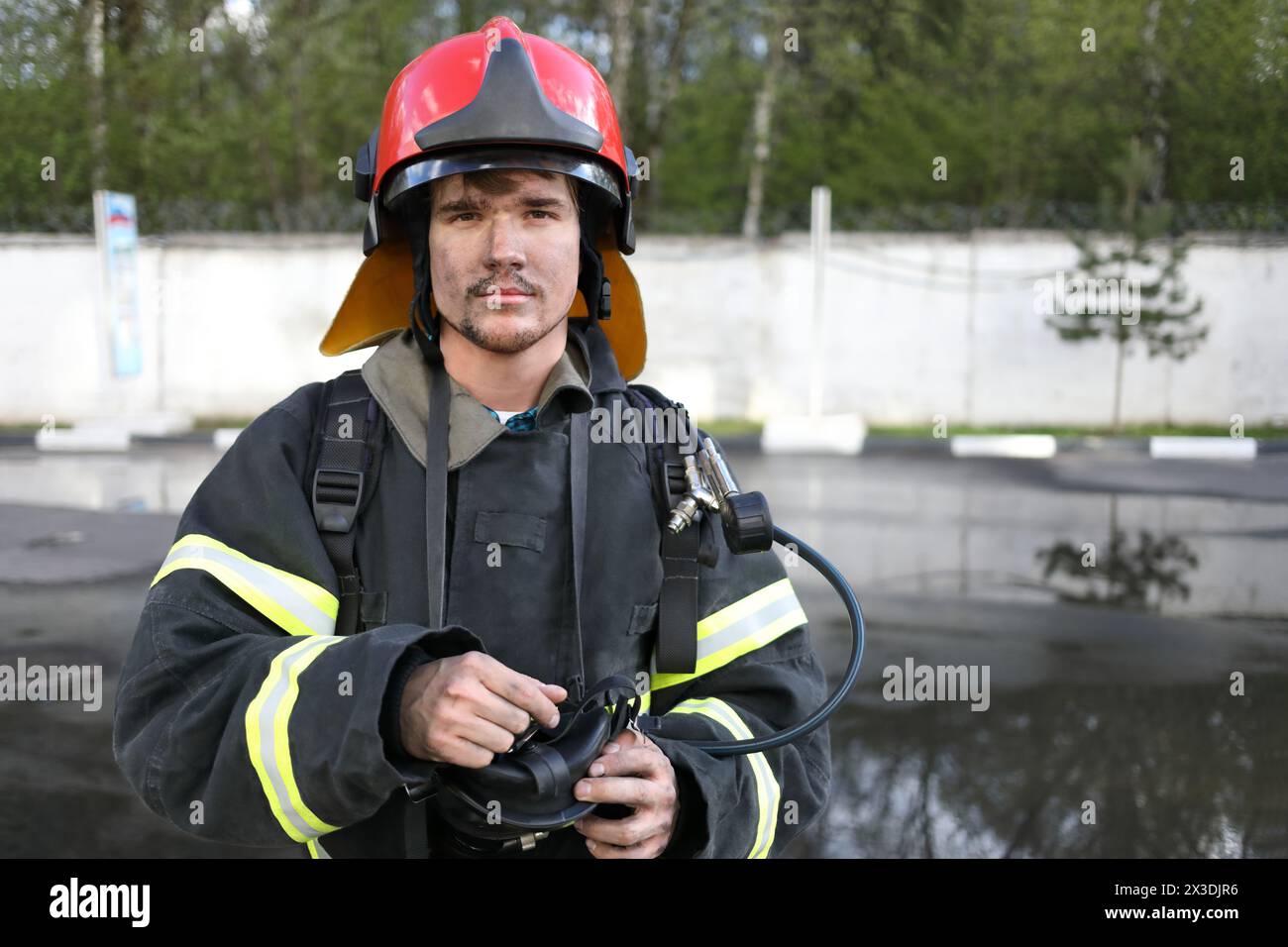 Portrait of fireman wearing fire fighter turnouts and red fire helmet ...